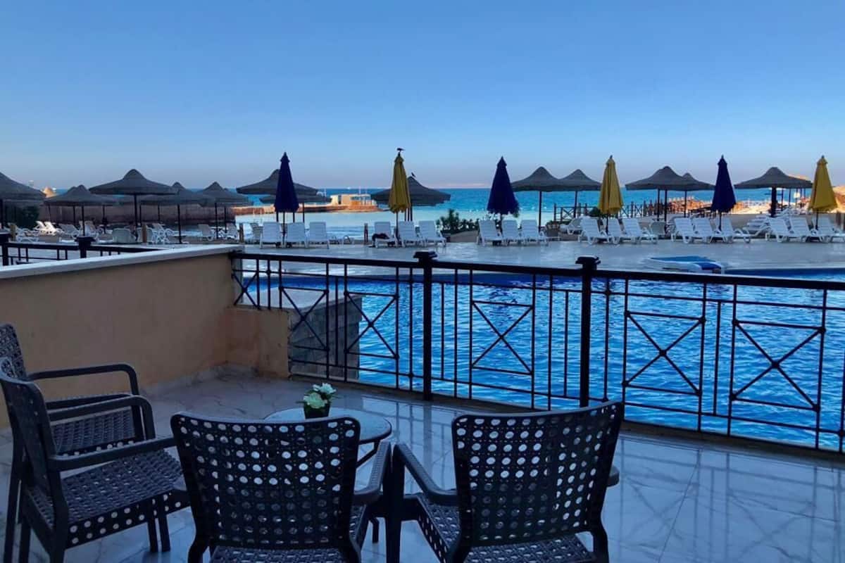 Terraço no telhado com piscina, espreguiçadeiras e guarda-sóis.