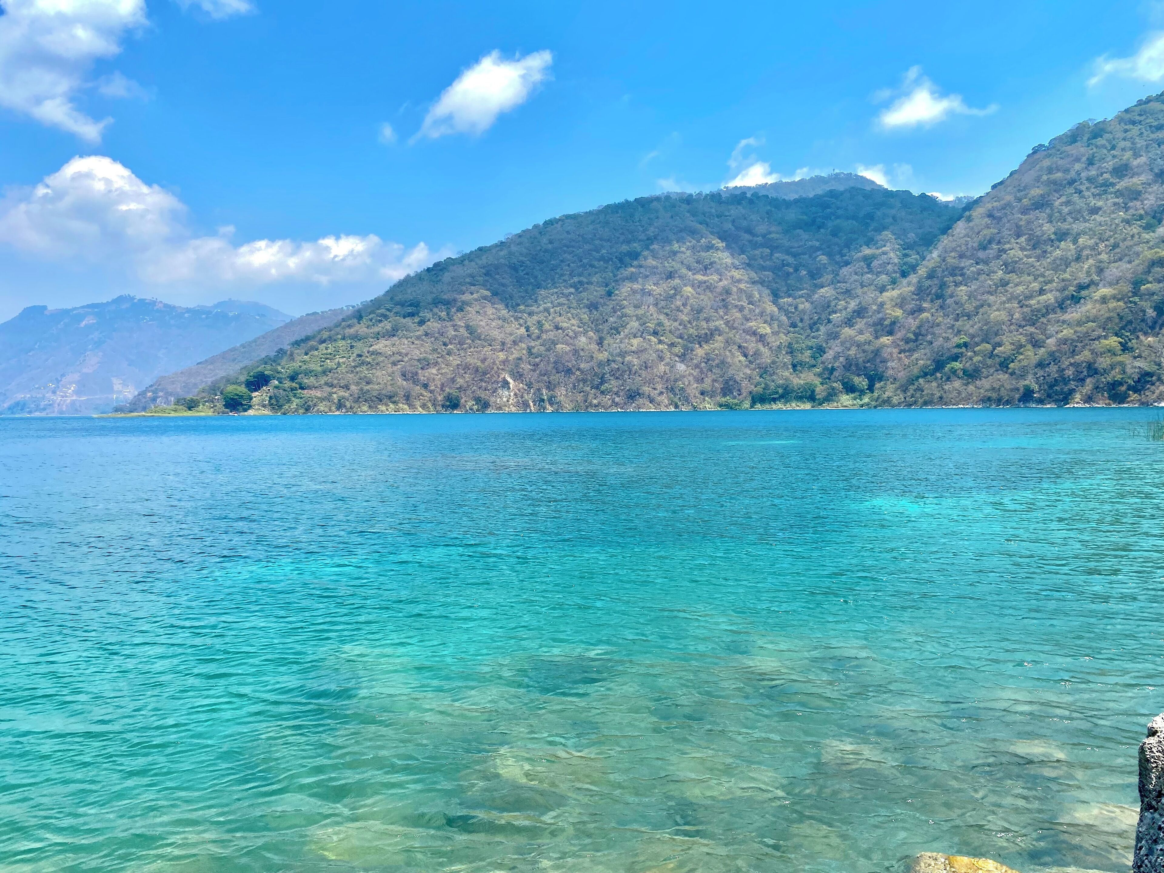 Vista clara de um lago com montanhas ao fundo.