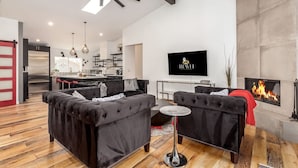 Uma sala de estar moderna com lareira, televisão e área de refeições.