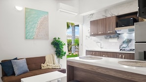 Uma cozinha moderna com bancada de mármore, armários de madeira e micro-ondas embutido.