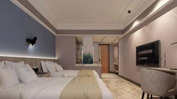 Quarto de hotel com duas camas, televisão, escrivaninha e uma cadeira.