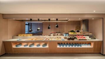 Cozinha moderna com serviço de buffet, incluindo diversos alimentos e utensílios.