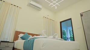 Quarto de hotel com cama, cortinas, ar condicionado e vista para o exterior.
