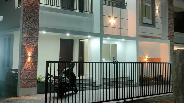 Uma casa moderna de dois andares, com varanda, garagem e entrada cercada.