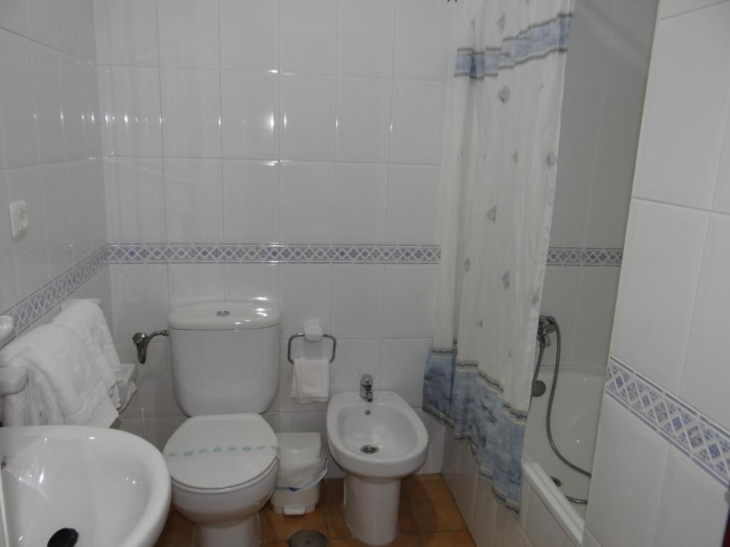 Casa de banho com sanita, bidé e lavatório.