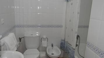 Casa de banho com sanita, bidé e lavatório.