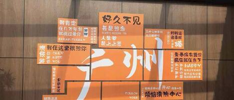 Paredes com vários sinais laranja contendo texto em chinês, provavelmente transmitindo mensagens ou informações.
