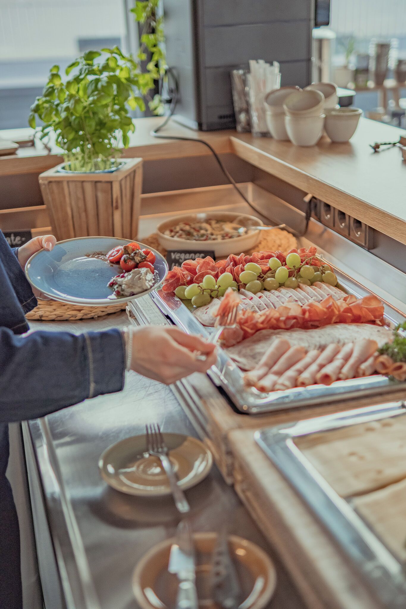 Uma mesa de buffet com diversos alimentos, incluindo carnes, queijos e frutas.