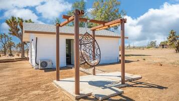 Um pequeno edifício térreo com fachada branca e telhado inclinado.