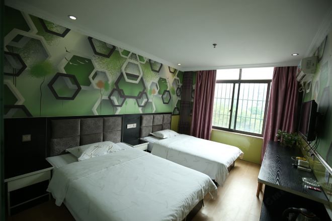 Quarto de hotel com duas camas, uma escrivaninha e uma janela com cortinas.