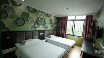 Quarto de hotel com duas camas, uma escrivaninha e uma janela com cortinas.