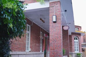 Edifício de tijolos com uma placa indicando o quarto 54, uma janela e uma porta.