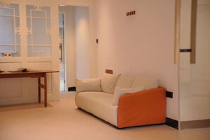 Quarto com sofá, mesa e porta.