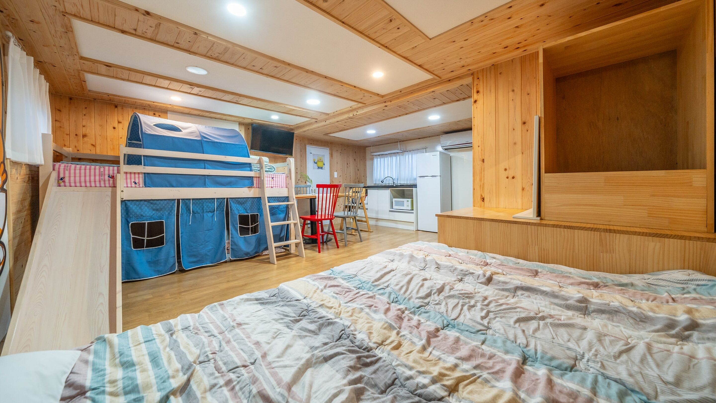 Um quarto aconchegante com beliches, uma cozinha compacta e um espaço para refeições.
