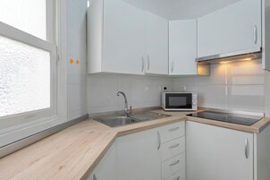 Um frigorífico/congelador grande, um micro-ondas, uma placa de cozinha 