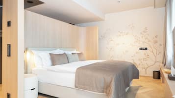 Quarto moderno com cama, mesa de cabeceira e parede com design de árvore.