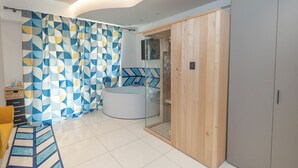 Um banheiro moderno com cortina de chuveiro estampada em padrão geométrico, box de vidro e armário de madeira.