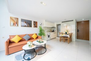 Uma sala de estar moderna com sofá, mesa de centro e área de jantar.