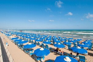 Uma praia privada, espreguiçadeiras, guarda-sóis de praia 