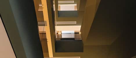 Interior moderno com teto alto, vários níveis e claraboia.