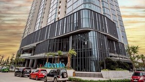 Um edifício alto e moderno com fachada curva e vários andares.