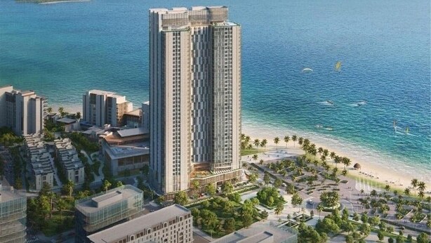 Um hotel alto com vista para a praia e o mar.