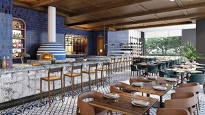 Um restaurante com área de bar, mesas e um forno grande.