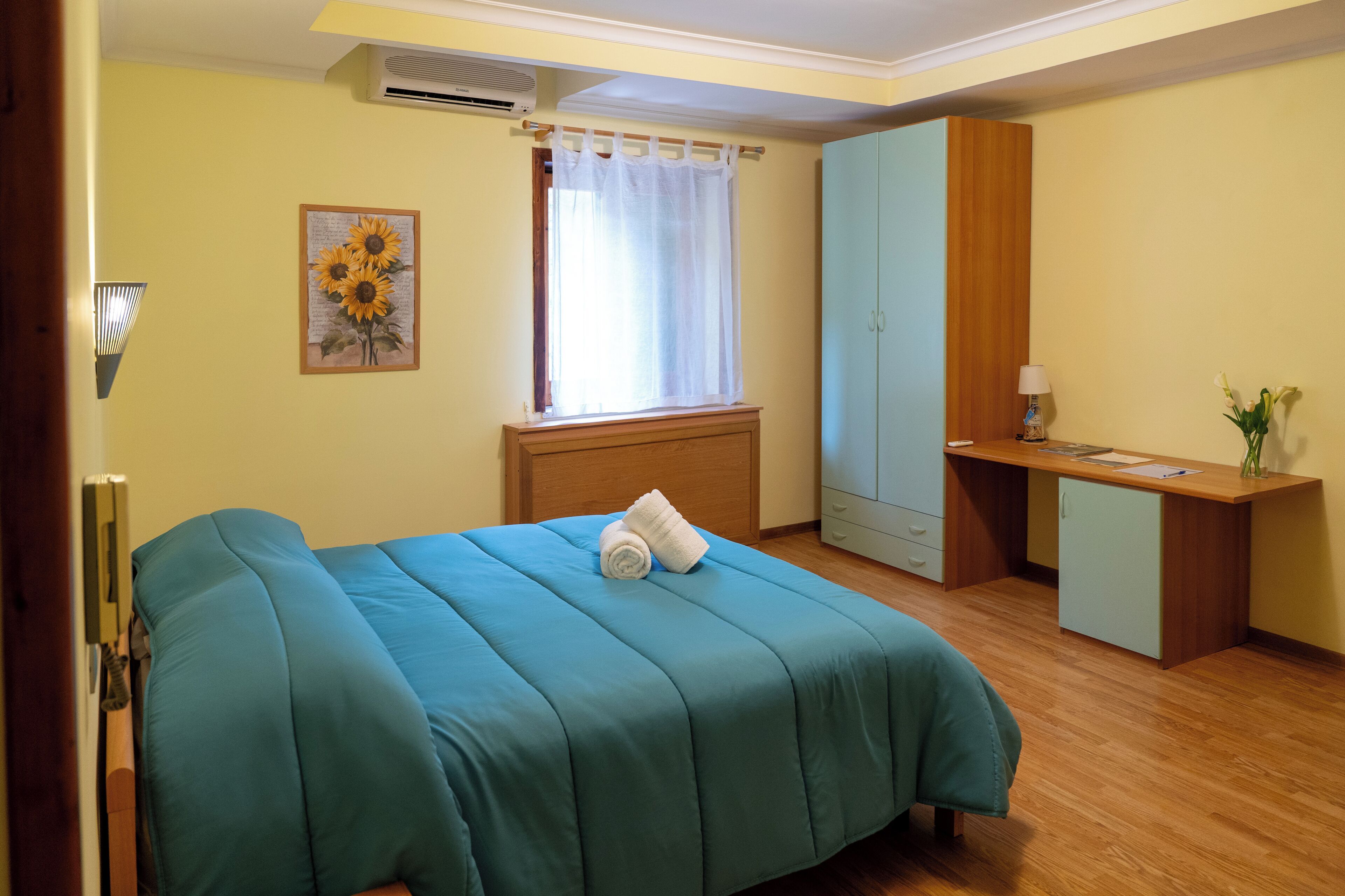 Quarto com cama, escrivaninha e guarda-roupa.