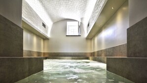 Um spa com uma banheira de hidromassagem grande, um claraboia e vista para o céu.