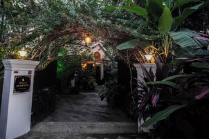Uma trilha leva a um edifício com uma placa que diz "Bella Homestay".