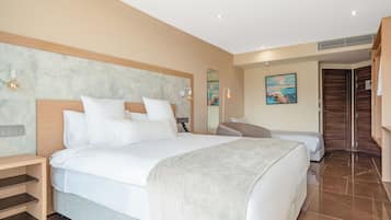 Quarto de hotel com uma cama grande, uma mesa de cabeceira, um espelho e um quadro na parede.