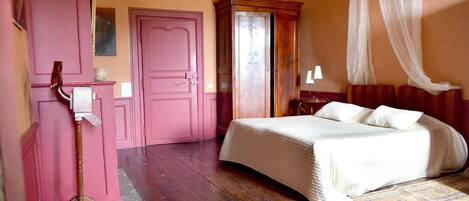 Quarto com cama, guarda-roupa, mesa de cabeceira e abajur.