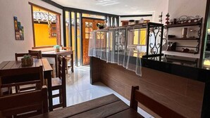 Uma área de refeições com mobiliário de madeira e um vaso de planta.