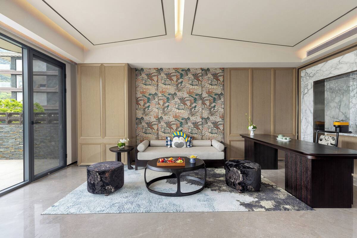 Uma sala de estar moderna com sofá, mesa de centro e um detalhe decorativo na parede.