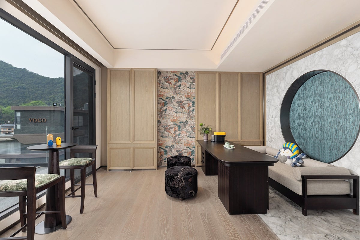 Interior moderno com área de jantar, assentos e vista para uma montanha.