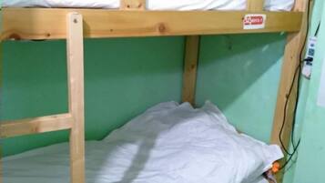 Uma cama beliche com estrutura de madeira e roupa de cama branca.