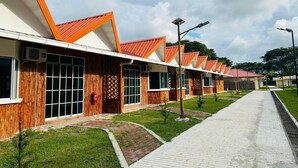 Fileira de quartos de hotel modernos com janelas amplas e telhado vermelho.