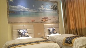 Quarto de hotel com duas camas, um grande mural de praia e vista para o oceano.