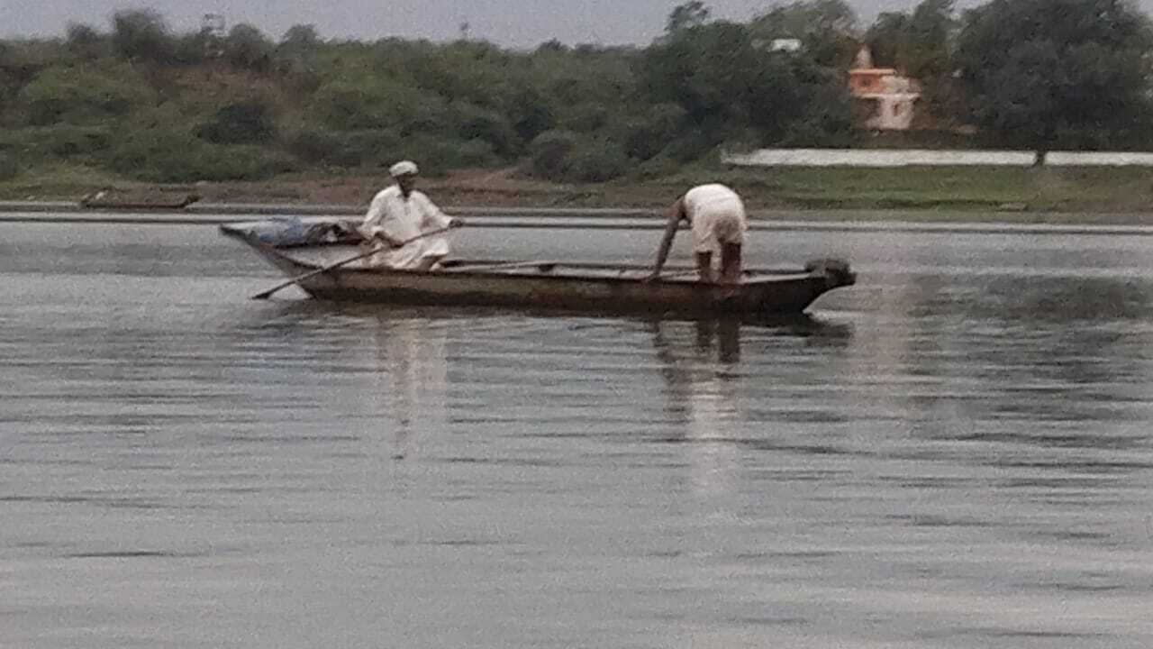 Duas pessoas em um barco sobre águas calmas.