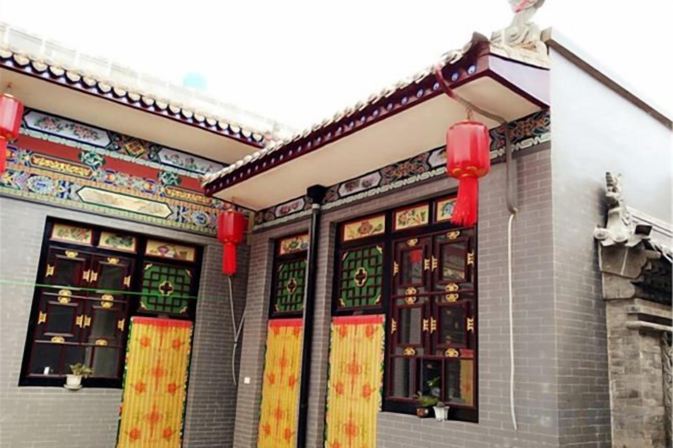 Um edifício tradicional com decorações elaboradas, telhado em azulejos e lanternas vermelhas.