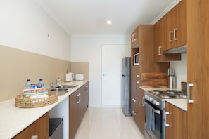 Um frigorífico, um micro-ondas, um forno, uma placa de cozinha