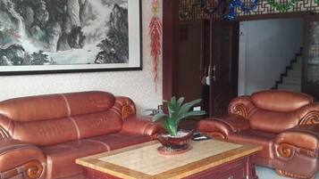 Uma sala de estar com sofás de couro, uma mesa de centro de madeira e uma obra de arte emoldurada na parede.
