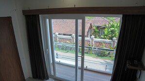 Quarto com uma grande porta de vidro deslizante que dá para uma varanda.