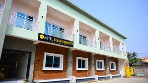 Um hotel de vários andares com uma placa que diz 'HOTEL BEACH COMFORTS'.