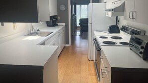 Uma cozinha moderna com armários brancos, forno embutido, fogão e torradeira.