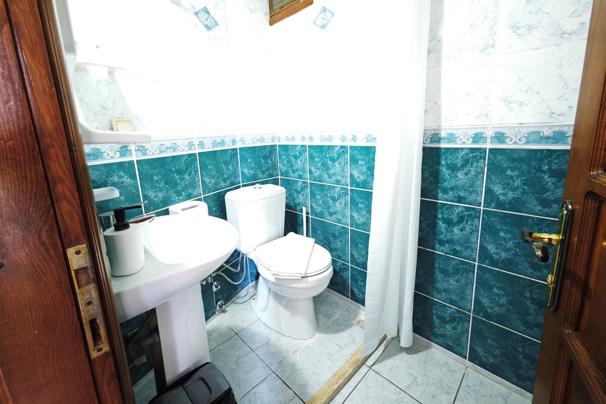 Casa de banho com sanita, lavatório e zona de duche.