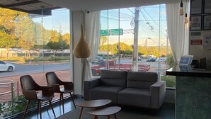 Uma sala de estar moderna com um sofá, duas mesas redondas e um lustre.