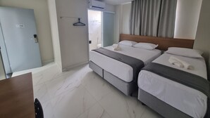 Quarto de hotel com duas camas, banheiro e porta com o número 206.