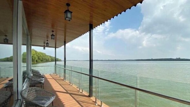 Um terraço coberto com assentos e vista para a água.