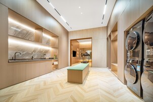 Uma cozinha moderna com painel de fundo de mármore, eletrodomésticos embutidos e padrão de piso em espinha de peixe.